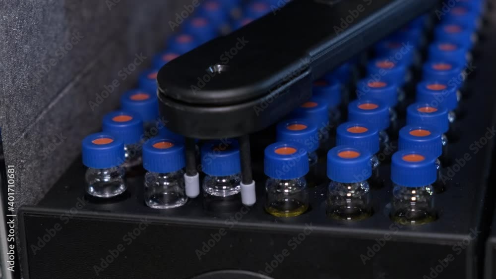 Automated conveyor line of auto sampler in HPLC system. Vials with blue ...