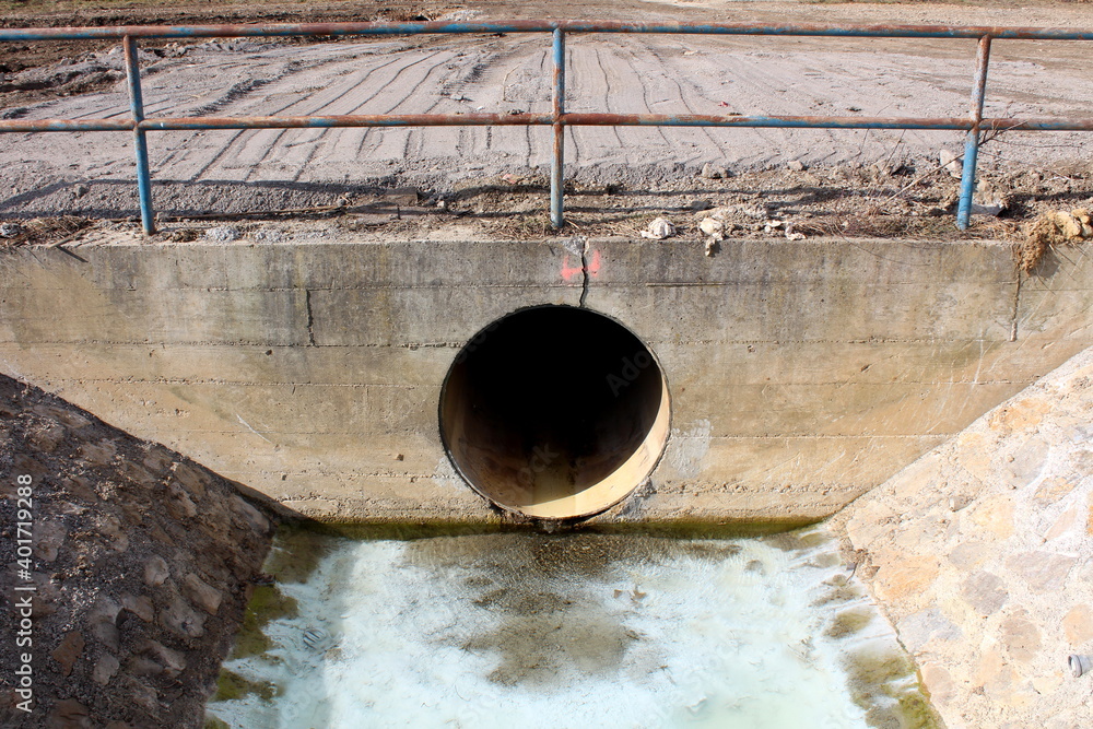 Small bridge with partially rusted metal railing over large diameter ...