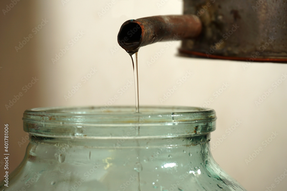 From the tube of the distillation cube flows into a jar of moonshine ...