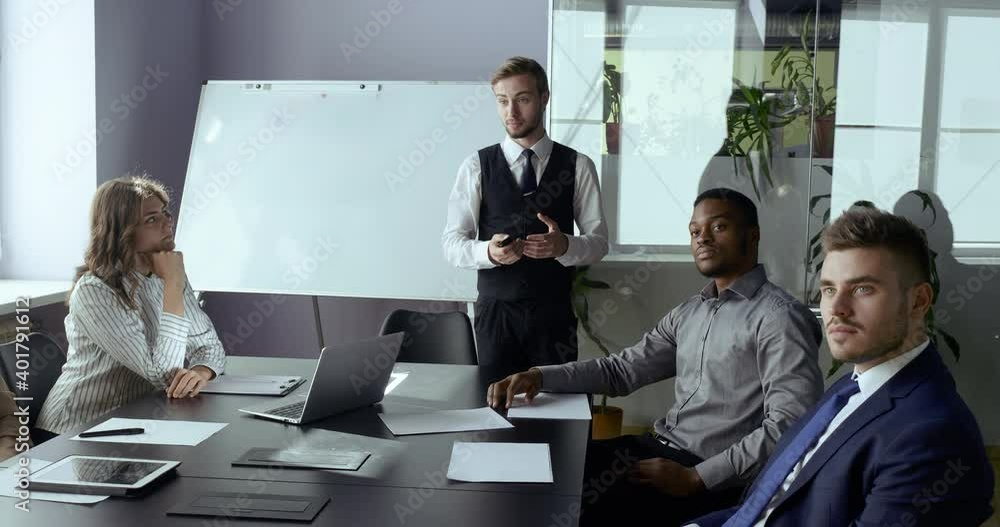 Attractive handsome leader of corporate standing by interactive board ...