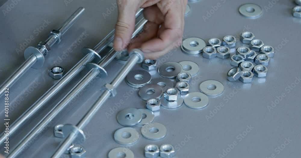 Furniture assembling worker prepares threaded rod and nuts making ...