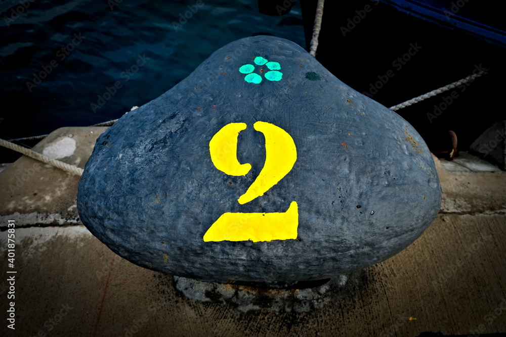 Number 2, two, a bold yellow digit on a black harbor bollard. Stock ...