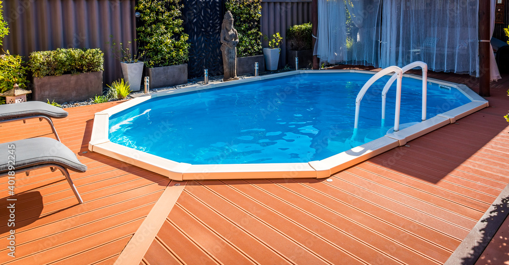 Above ground pool sunken below ground and surrounded by decking. Stock ...
