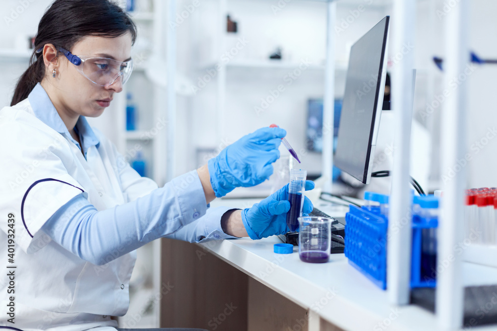 Woman scientist in lab during clinic experiement taking sample of ...