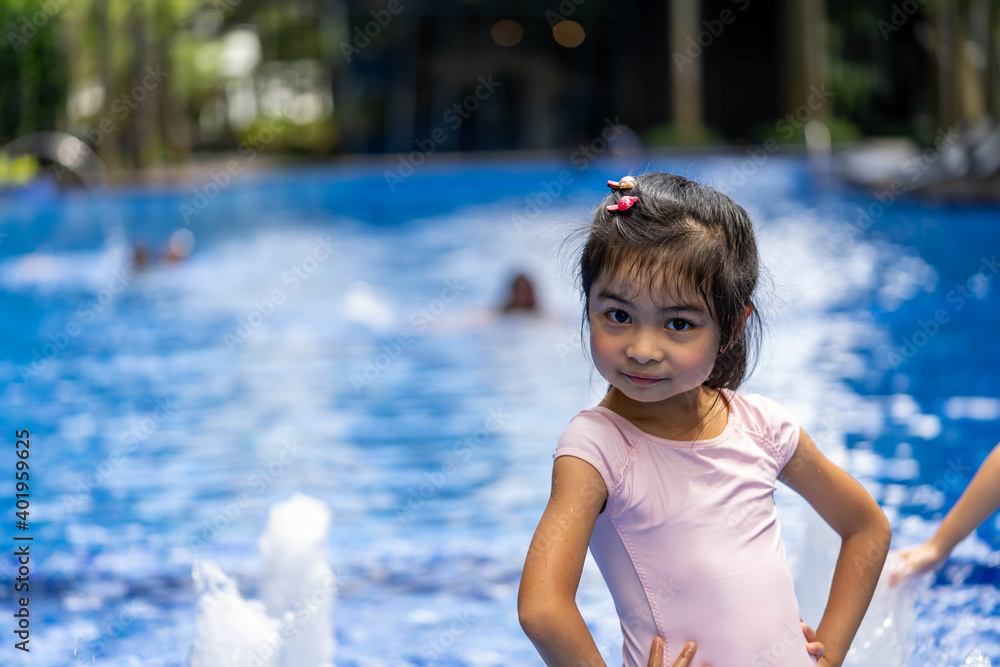 Portrait of pretty asian child smilling and posing on swimming pool ...
