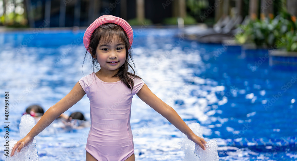 Portrait of pretty asian child smilling and posing on swimming pool ...