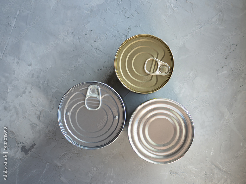Fotka „Various canned foods in tin cans on concrete grey background ...