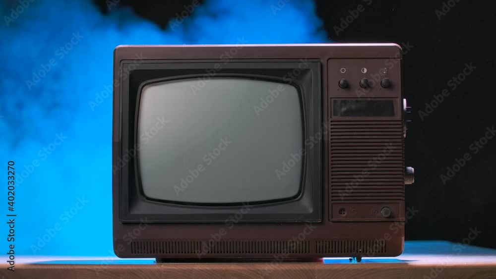 Vintage television against a smoky studio background with blue neon ...