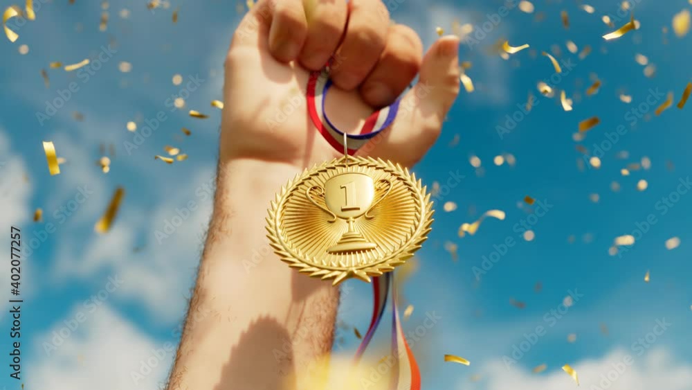 Rising hand holding a shiny gold medal. Top winner with first prize ...