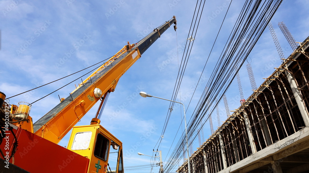 Mobile cranes at construction sites. A large yellow truck mounted crane ...