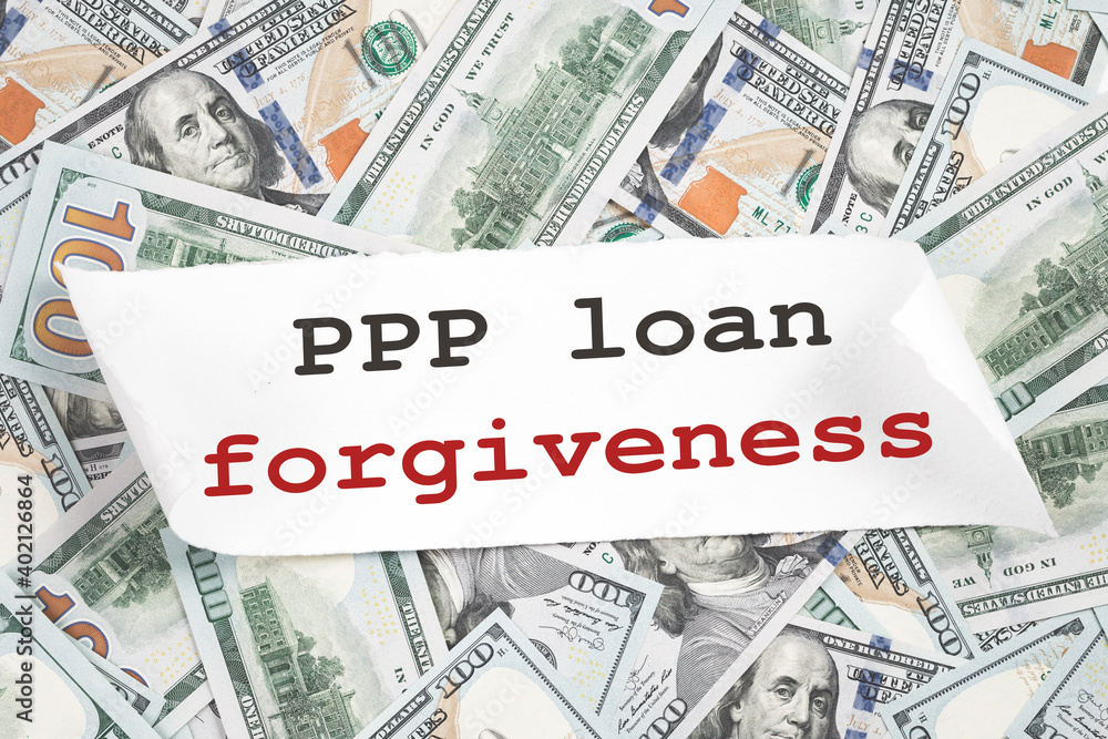 PPP loan forgiveness text note on hundred dollar bill notes. Cash Money ...