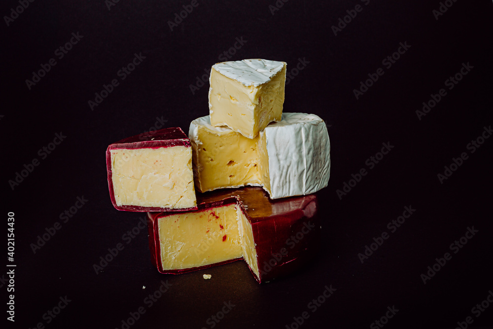 Assortment of different cheese types on dark and white background ...