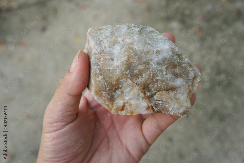 Raw quartzite rock stone in a hand. Quartzite is a nonfoliated ...