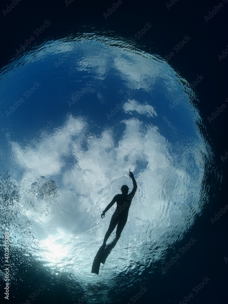 free diver silhouette underwater with sun and clous in the sky ocean ...