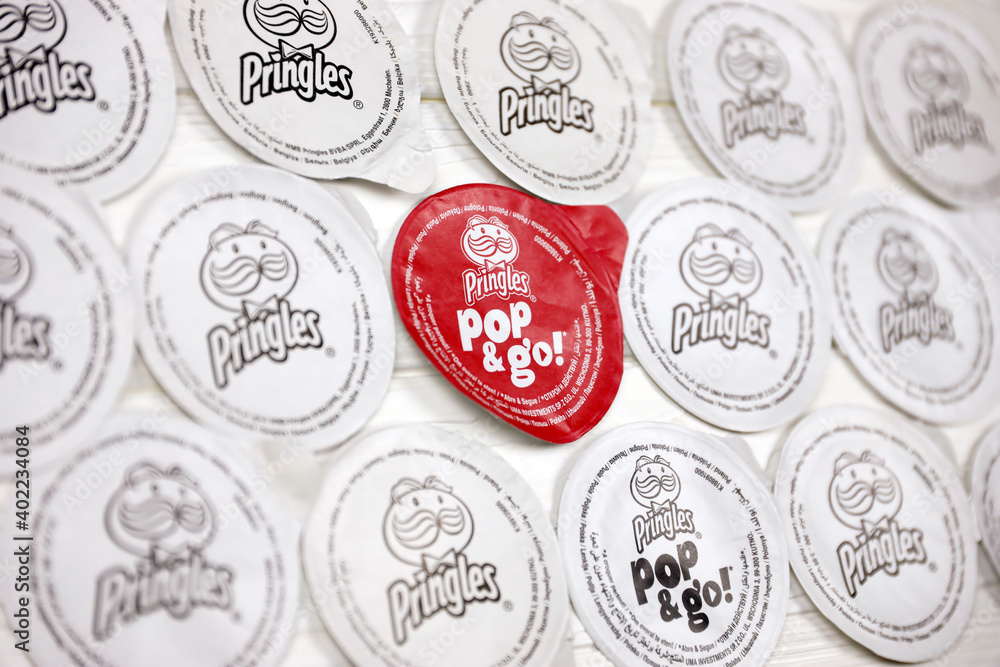 Pringles logo on paper membranes on white wooden table. Pringles is a ...