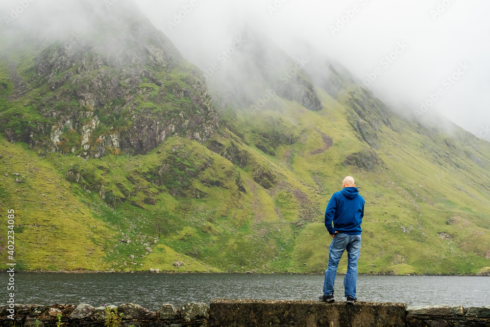 Bald male tourist enjoy view in Connemara region, Ireland. Man standing ...