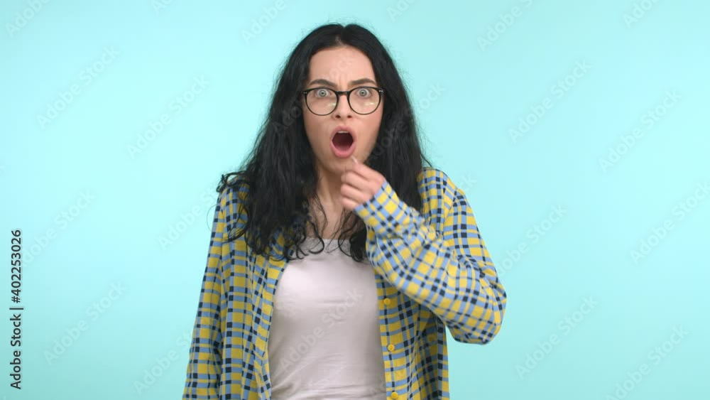 Young woman looking at something scary, gasping and staring alarmed ...