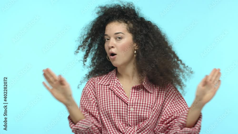 Slow motion of reluctant stylish girl with curly long hair, saying no ...