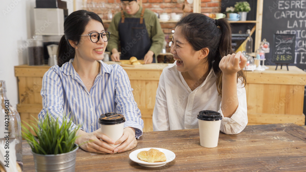 happy young female people eating croissant and drinking coffee in cafe ...