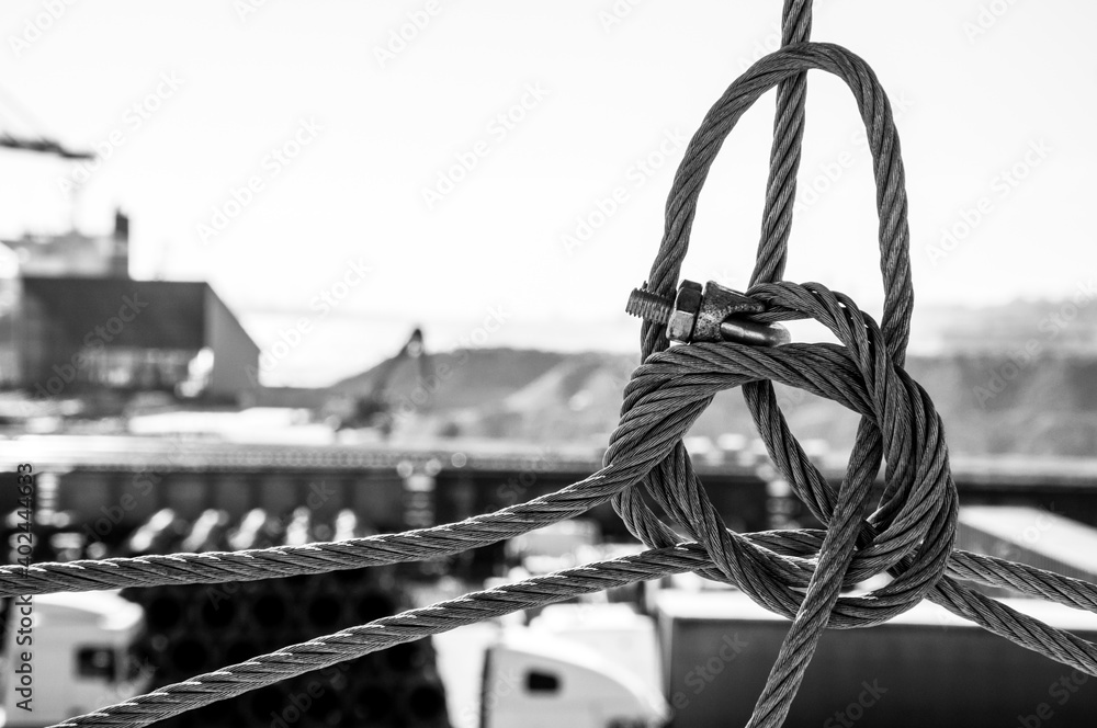 Black and white photo of wire rope knot closeup with blurred industrial ...