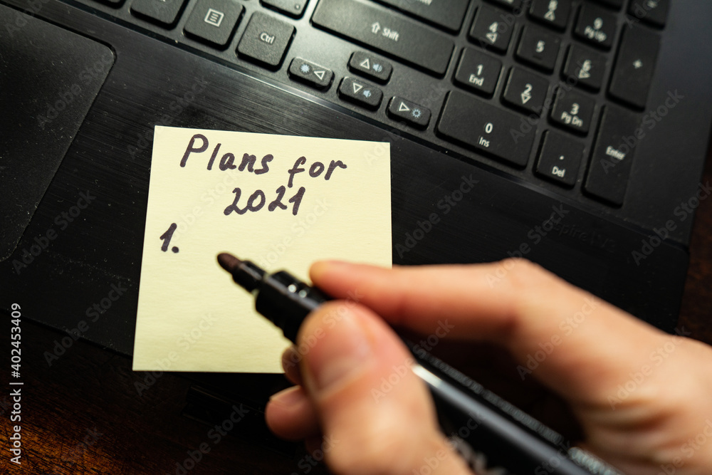 Check boxes on white paper plans for 2021. hand with black marker makes ...