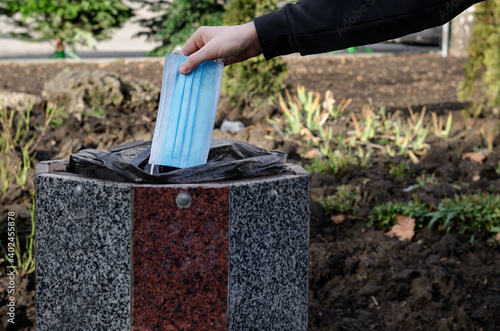 Man throws out a medical mask. Man throwing face masks into trash ...