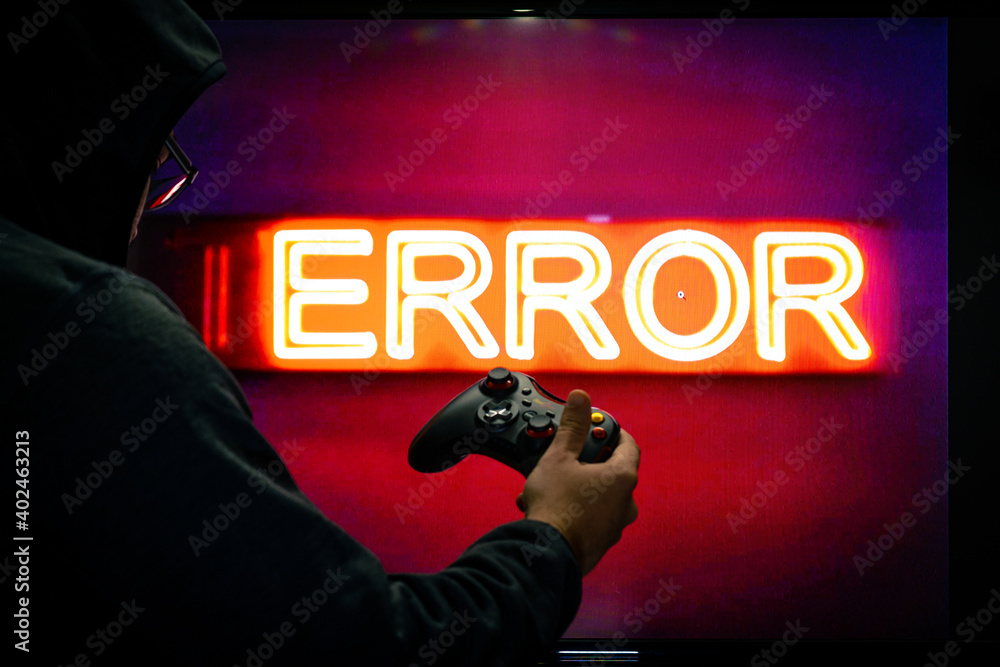 Man holding a controller in front of a screen showing an error message ...