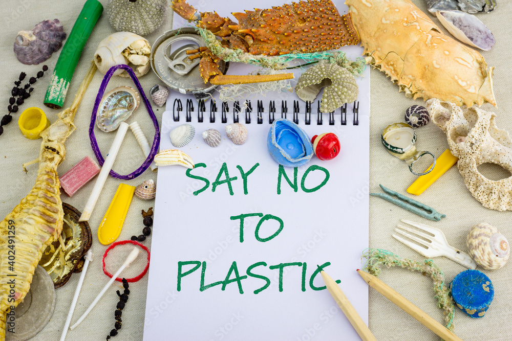 Say No to Plastic handwritten on notebook surrounded by real plastic ...