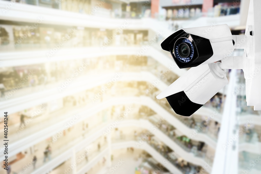 Modern public CCTV camera with blur interior shopping mall background ...
