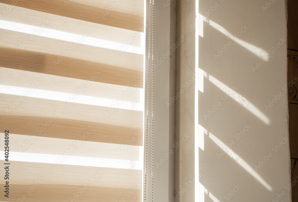 beige roller blinds day night on the window in the daytime in the sun ...