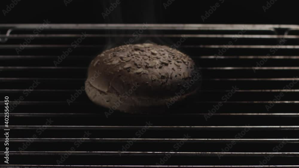 Close up of burnt bread inside the oven with metal bars on black ...