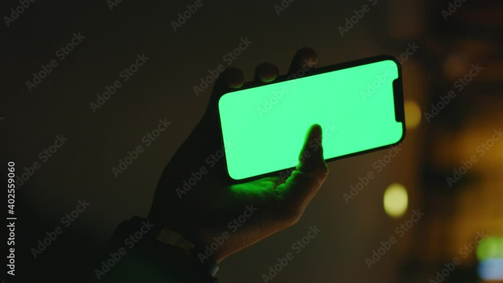 Vertical shot hands man use phone with vertical green screen stand at ...