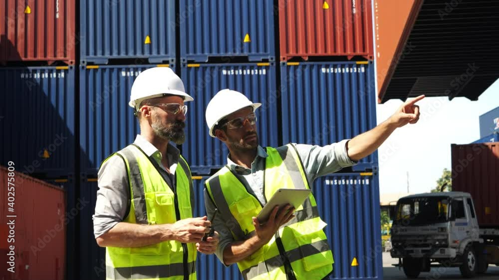 Two Foreman control loading containers box in container yard from cargo ...
