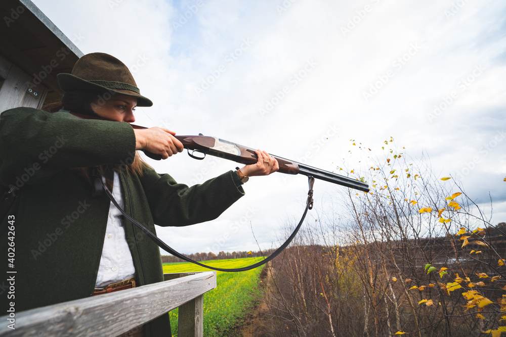 Foto de Jagd und Wildhege, junge Jägerin zielt auf flüchtendes Wild ...