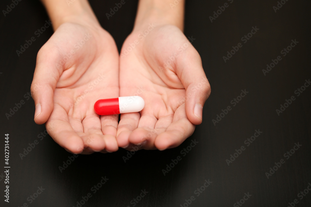 two palms of the hand lies a pill large capsule red and white gives you ...