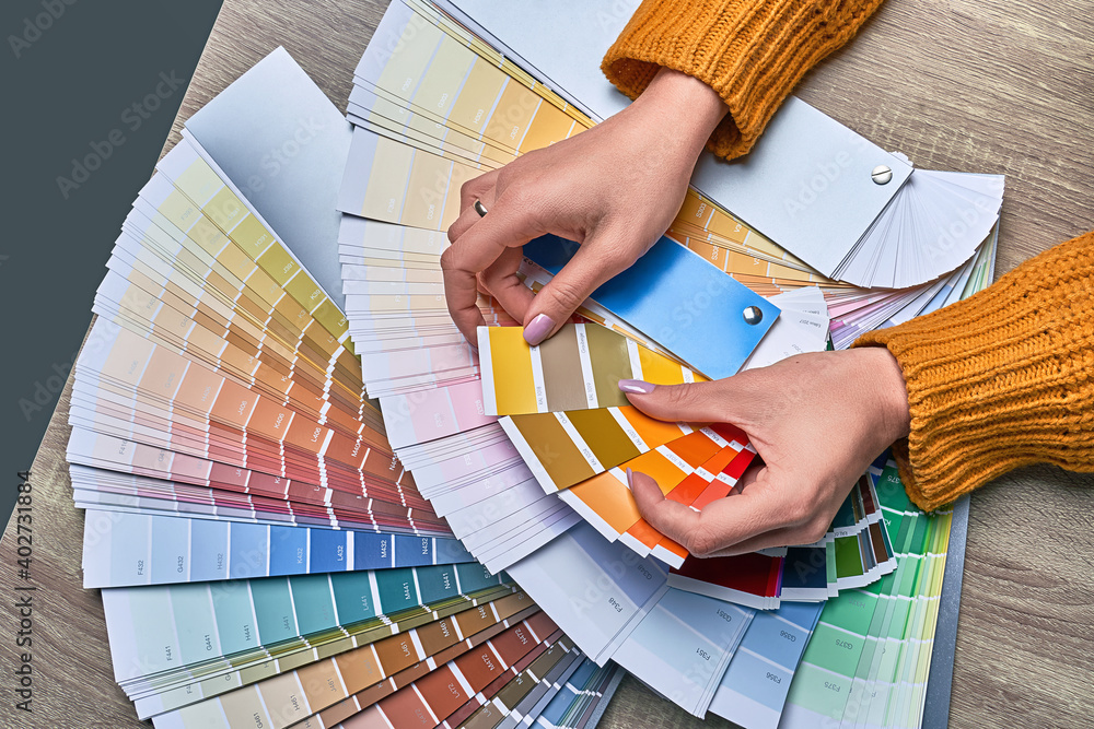 Color wheel for choosing paint tone. Hands of female interior designer ...
