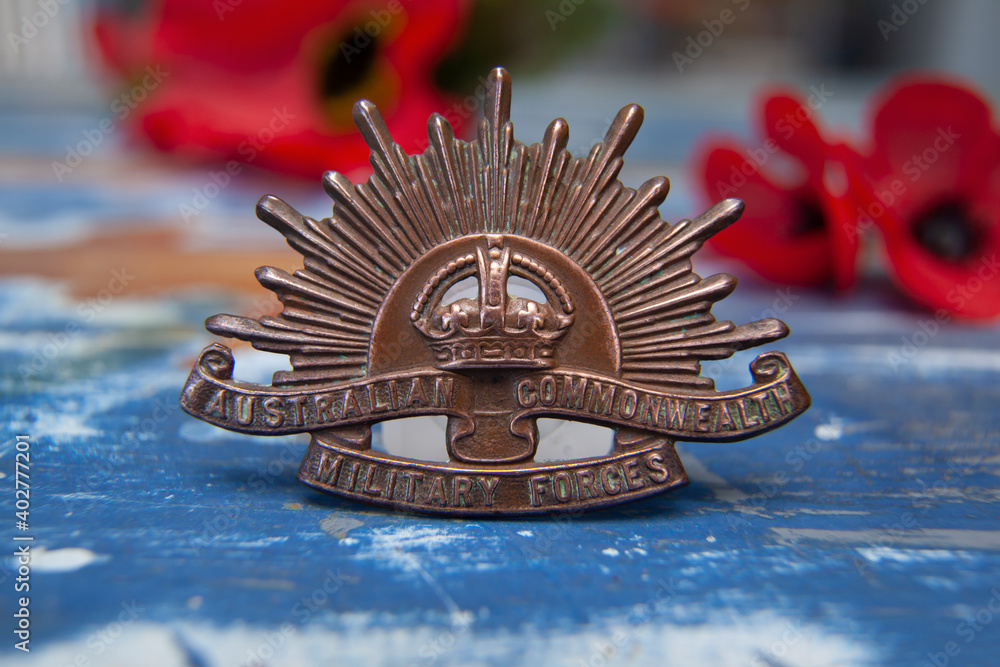 Vintage World War 2 Australian army rising sun badge on textured blue ...