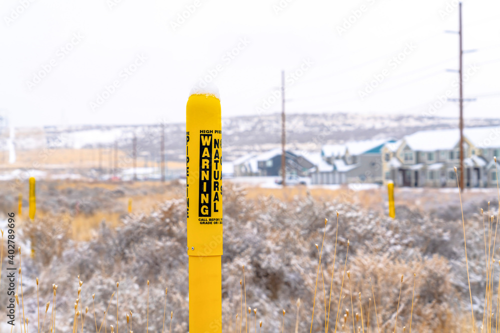 Yellow pole with warning sign for natural gas pipeline buried ...