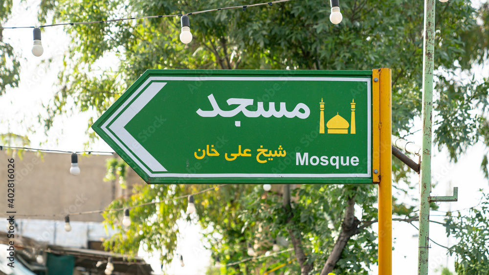 Street sign indicating the direction to a Muslim mosque in Iran. Arabic ...
