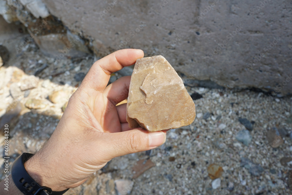 Hand holding a piece raw Quartzite rock. Quartzite is a metamorphic ...