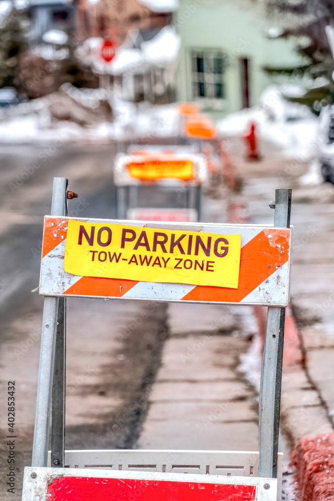No Parking sign and traffic barriers on the road against blurry ...