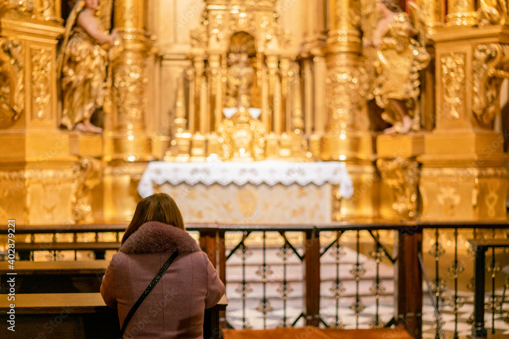 A woman in a temple prays to God. Woman praying in front of altar ...