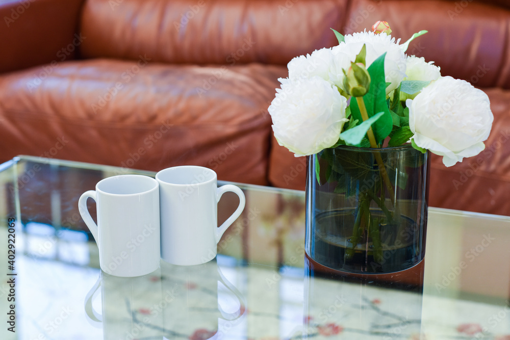 Two cups of tea or coffee together on a coffee table in a light home ...