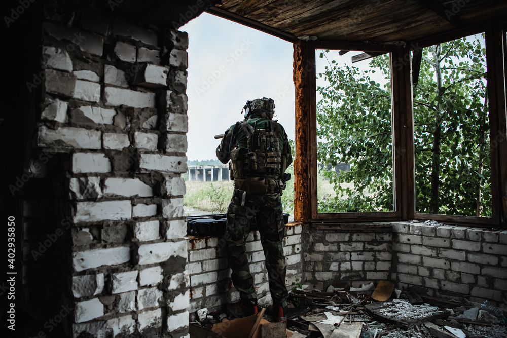 Military man with gun case takes out an assault rifle in destroyed city ...