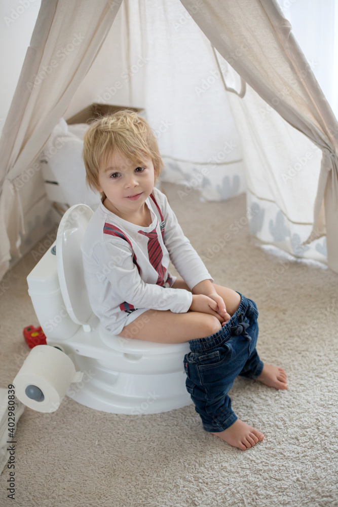 Cute toddler child, boy, sitting on a baby toilet potty, playing Stock ...