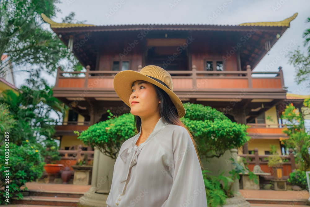 Happy asian woman walking outdoors in Buu Long Pagoda in Ho Chi Minh City. A beautiful buddhist ...