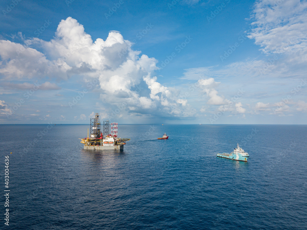 Offshore drilling rig (jack up rig) and tow vessels during the rig move operation in the middle ...