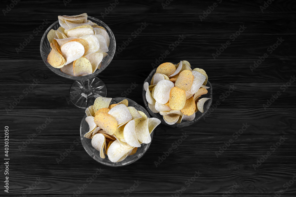 Many orange Pringles potato snack chips on black wooden table. Pringles ...