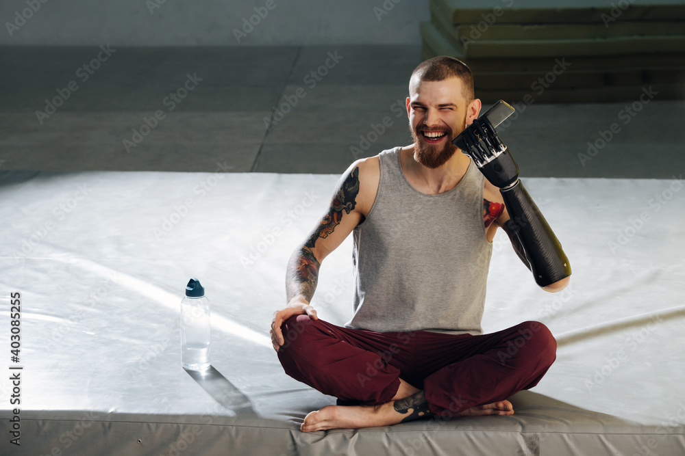 Funny cyborg man trying to hold his phone with bionic hand, laughing ...