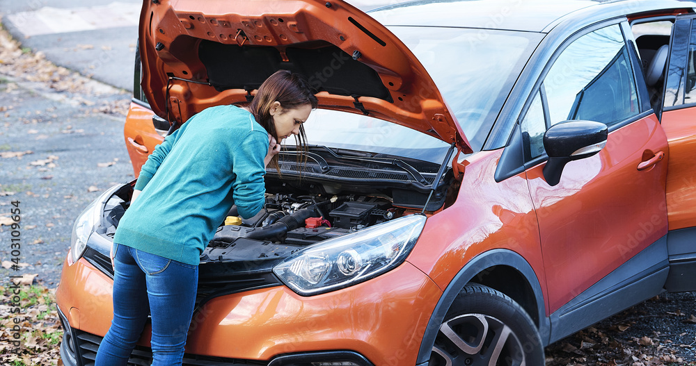 sad or angry beautiful woman inspecting the engine for car engine ...